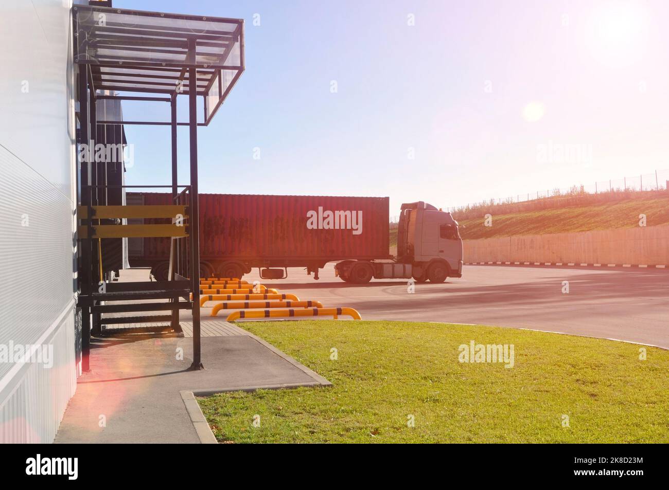 Unloading trucks in a modern warehouse complex at sunset. Illumination ...