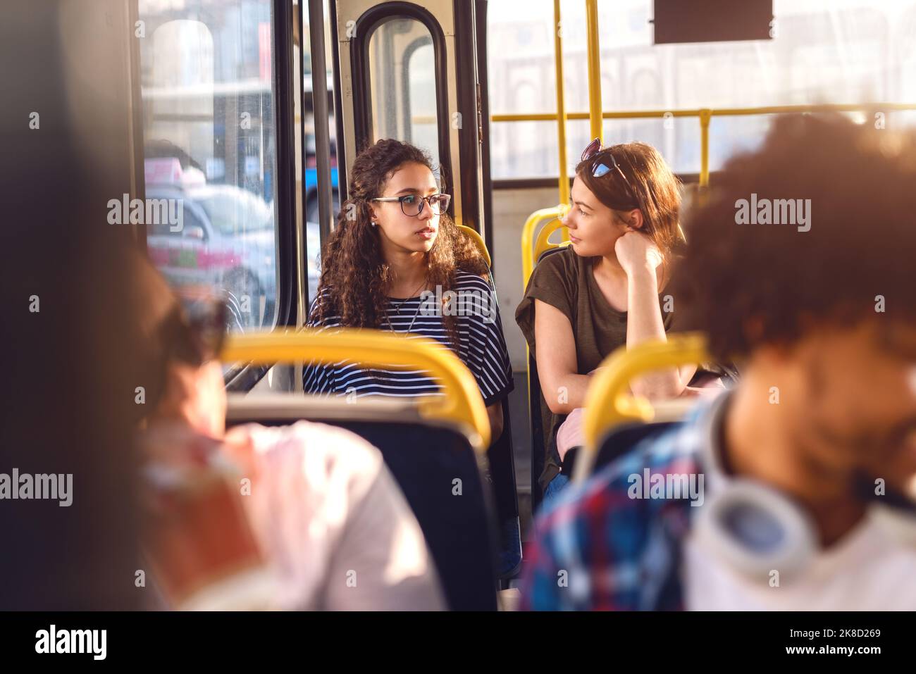 Two friends sitting in a bus, talking watching trough window Stock ...