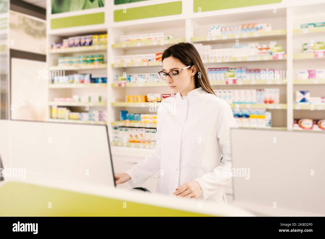 A pharmacist entering data on computer at pharmacy Stock Photo - Alamy