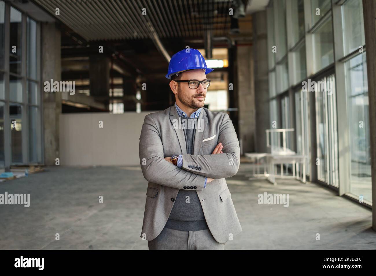 Serious architect standing in building in construction process with ...