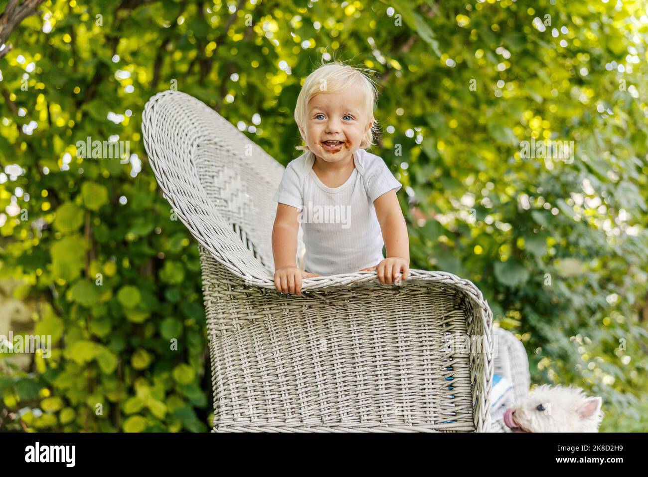 A clumsy baby smeared with chocolate. The baby is enjoying childhood, a ...