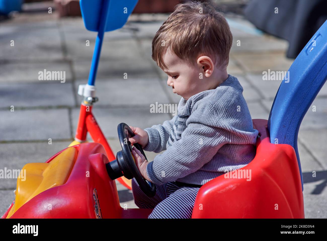 handsome young boy toddler is playing in a red push car Stock Photo - Alamy