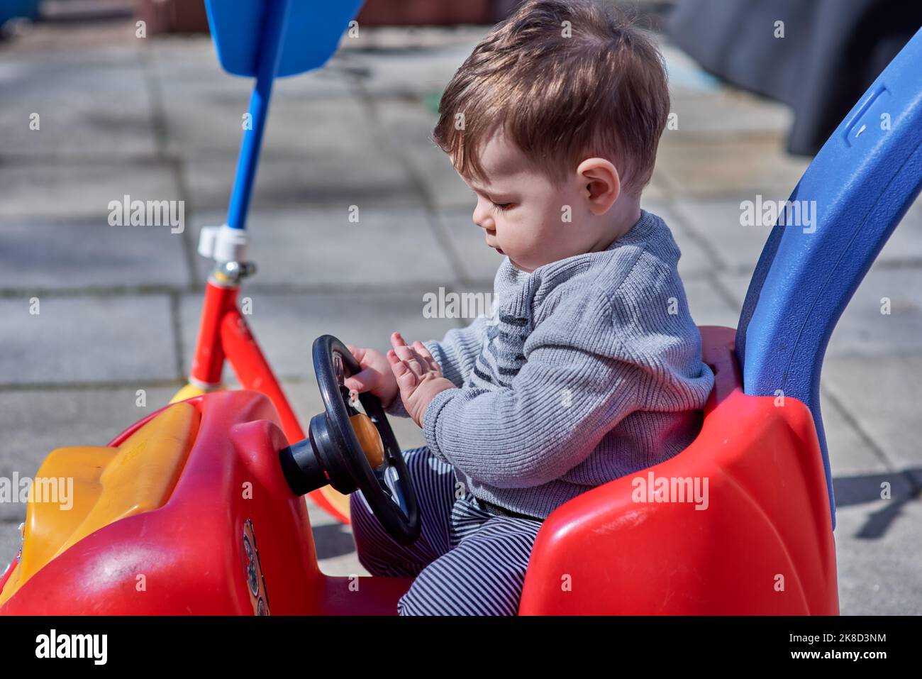 handsome young boy toddler is playing in a red push car Stock Photo - Alamy