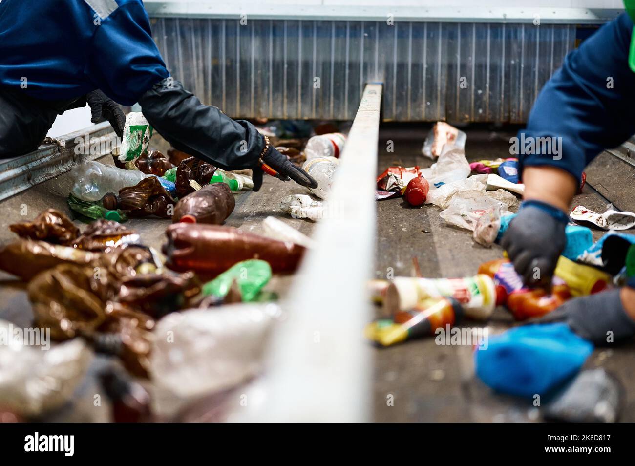 Worker sorts trash on conveyor belt at waste recycling plant Stock Photo - Alamy