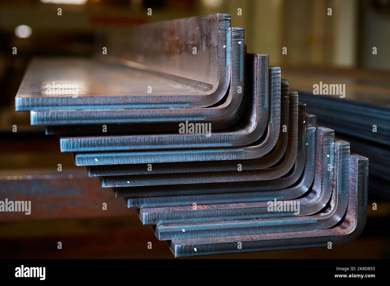Long bent metal details stacked at production plant Stock Photo - Alamy