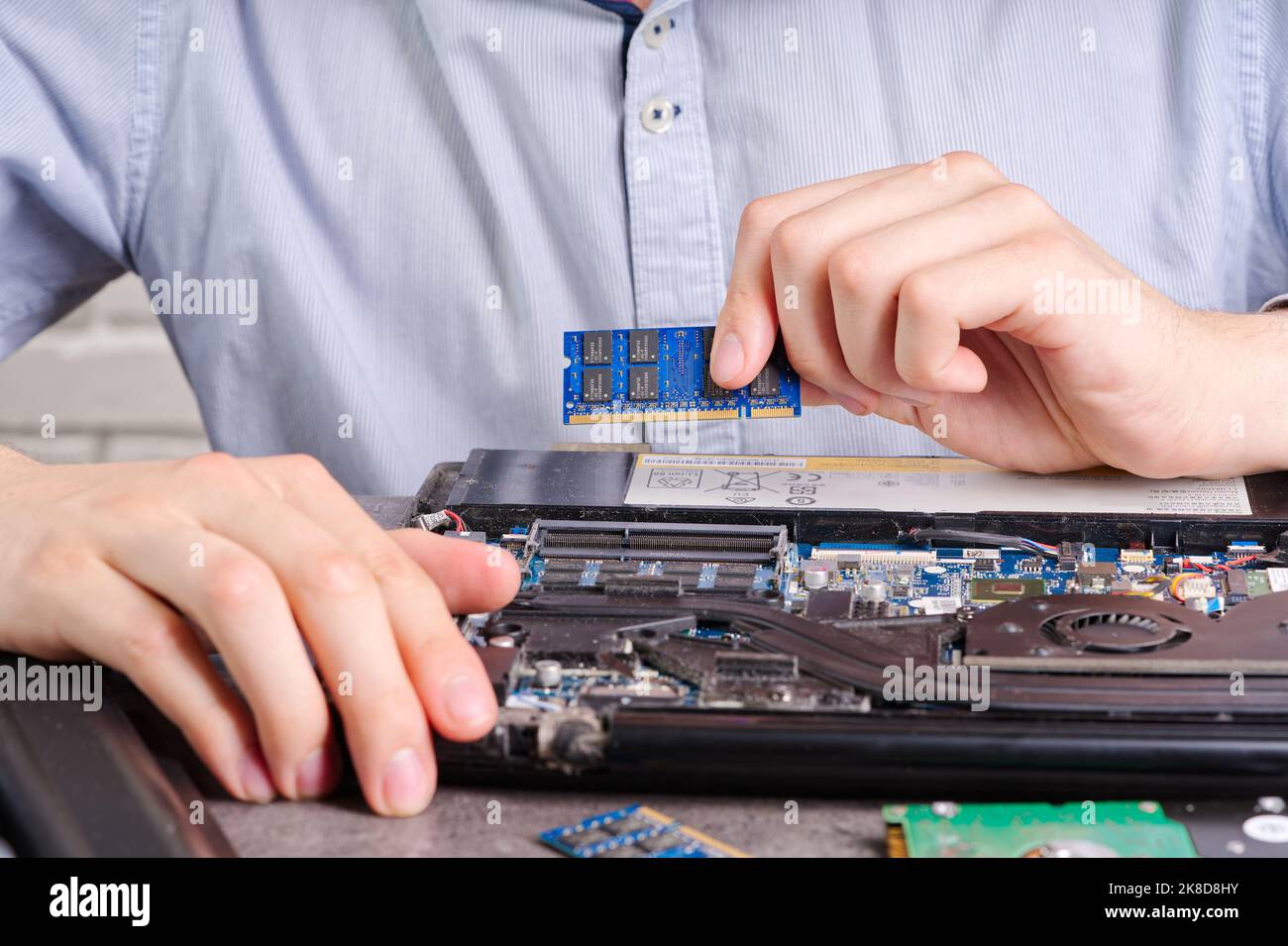 Man disassembles a laptop. Computer service and repair concept. Laptop disassembling in repair ...
