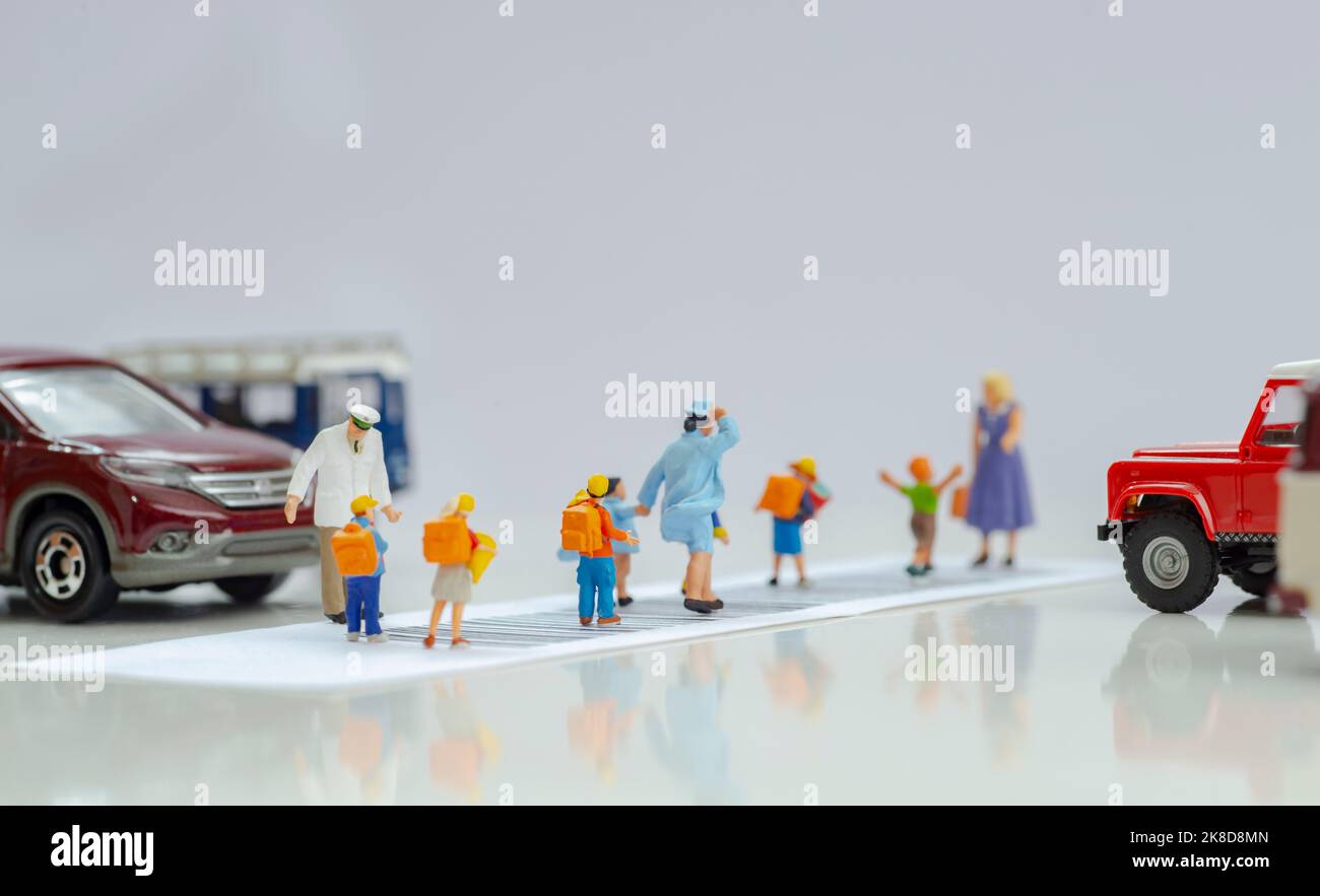 Illustrative editorial - Miniature toys school kids walk on cross road ...