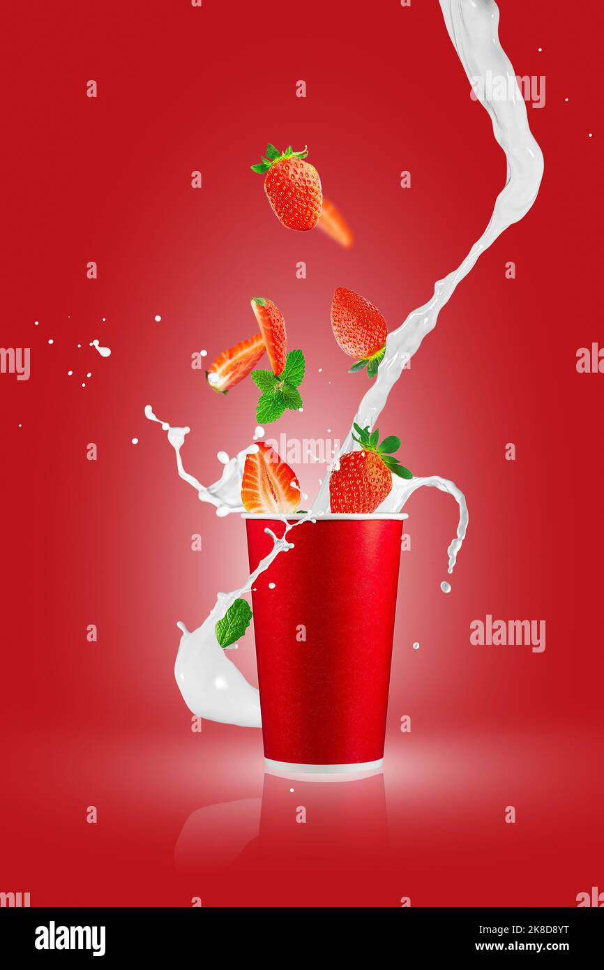 Strawberry berries falling in paper takeaway cup with milk splashes ...