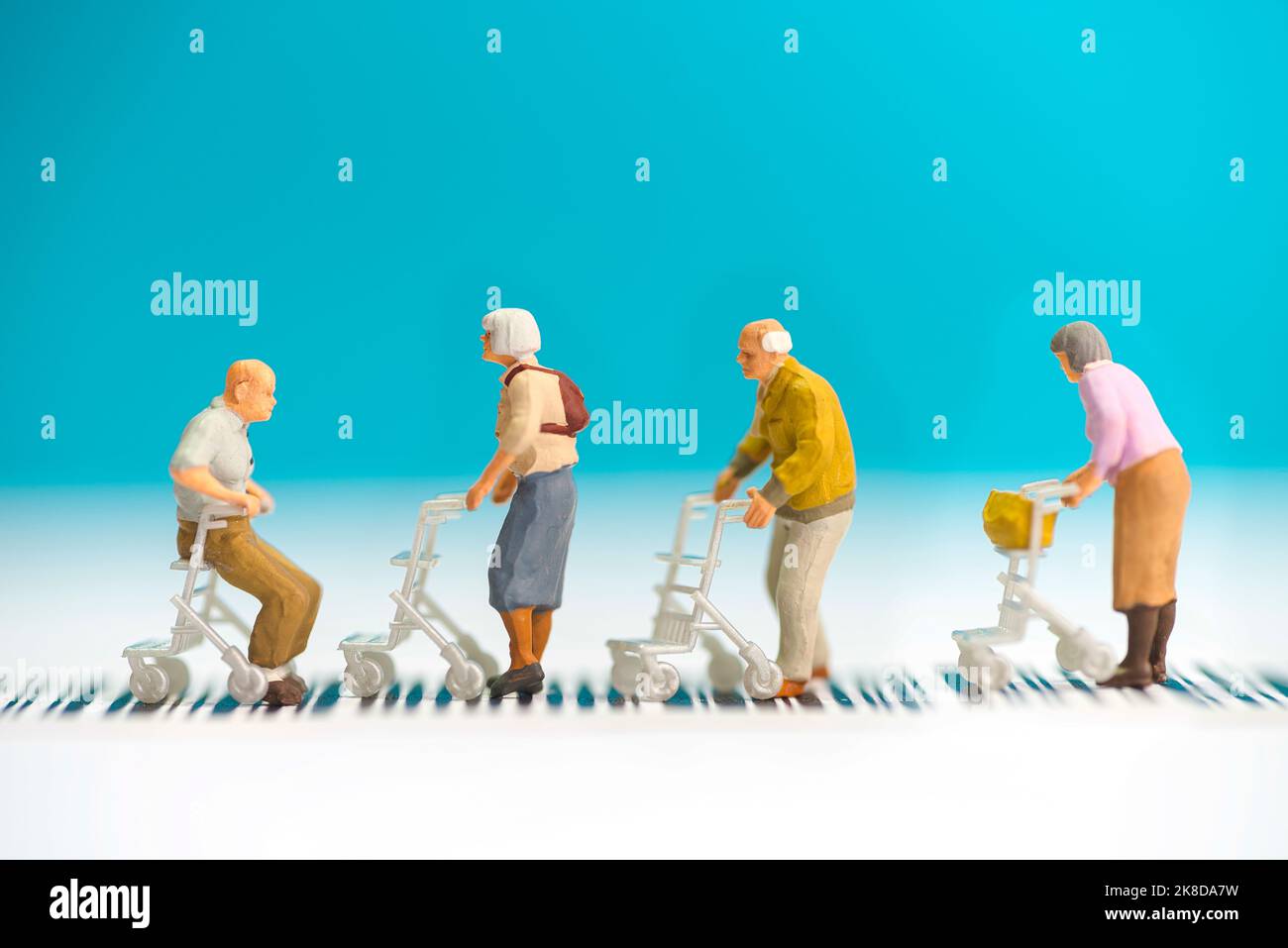 Miniature toys a group of old people with wheel chair crossing a road ...