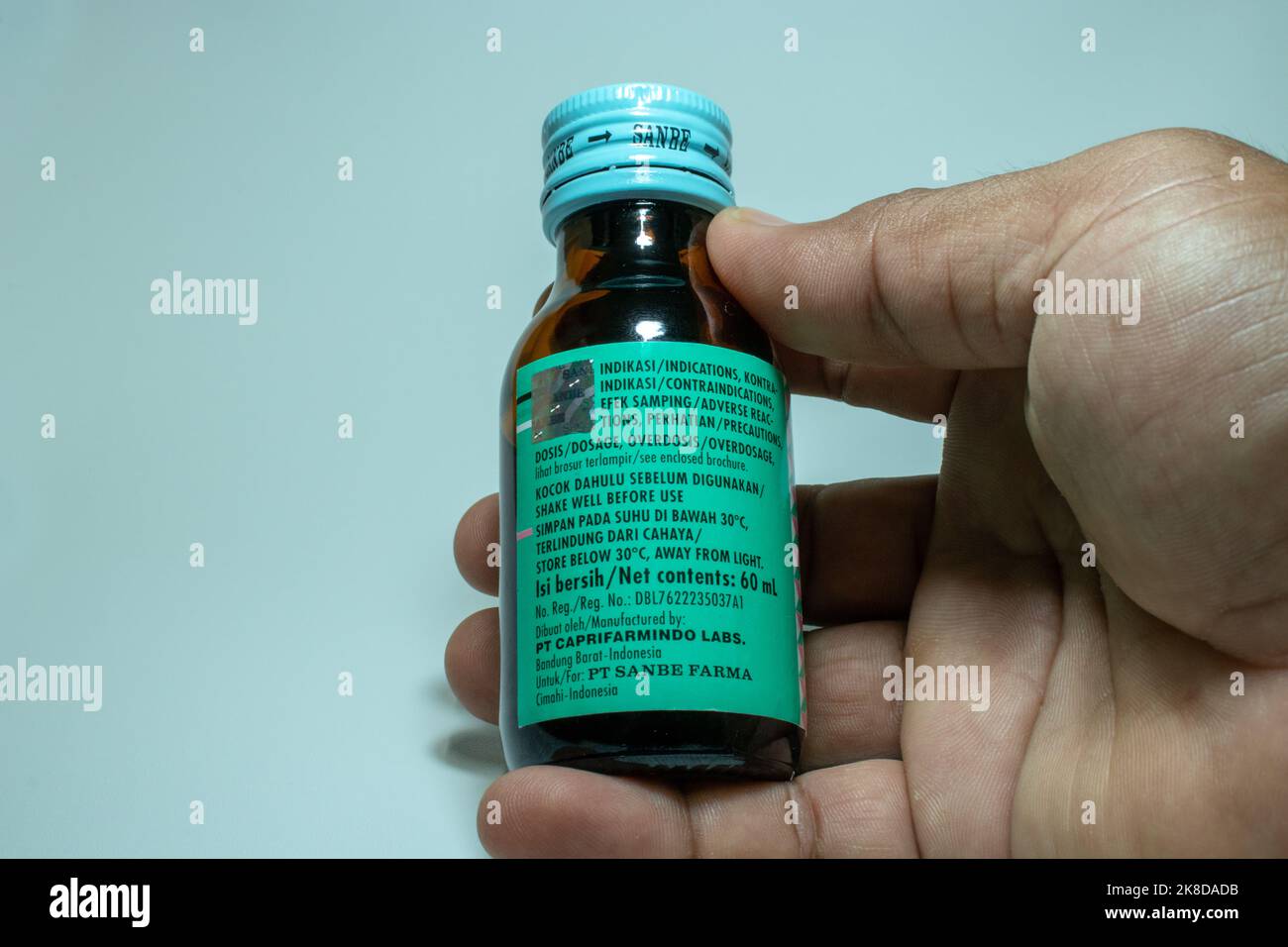 Hand holding a bottle of paracetamol syrup on a white background Stock ...