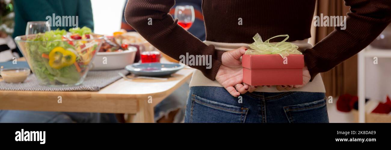 Happy family with mother giving gift box with daughter during dinner at ...