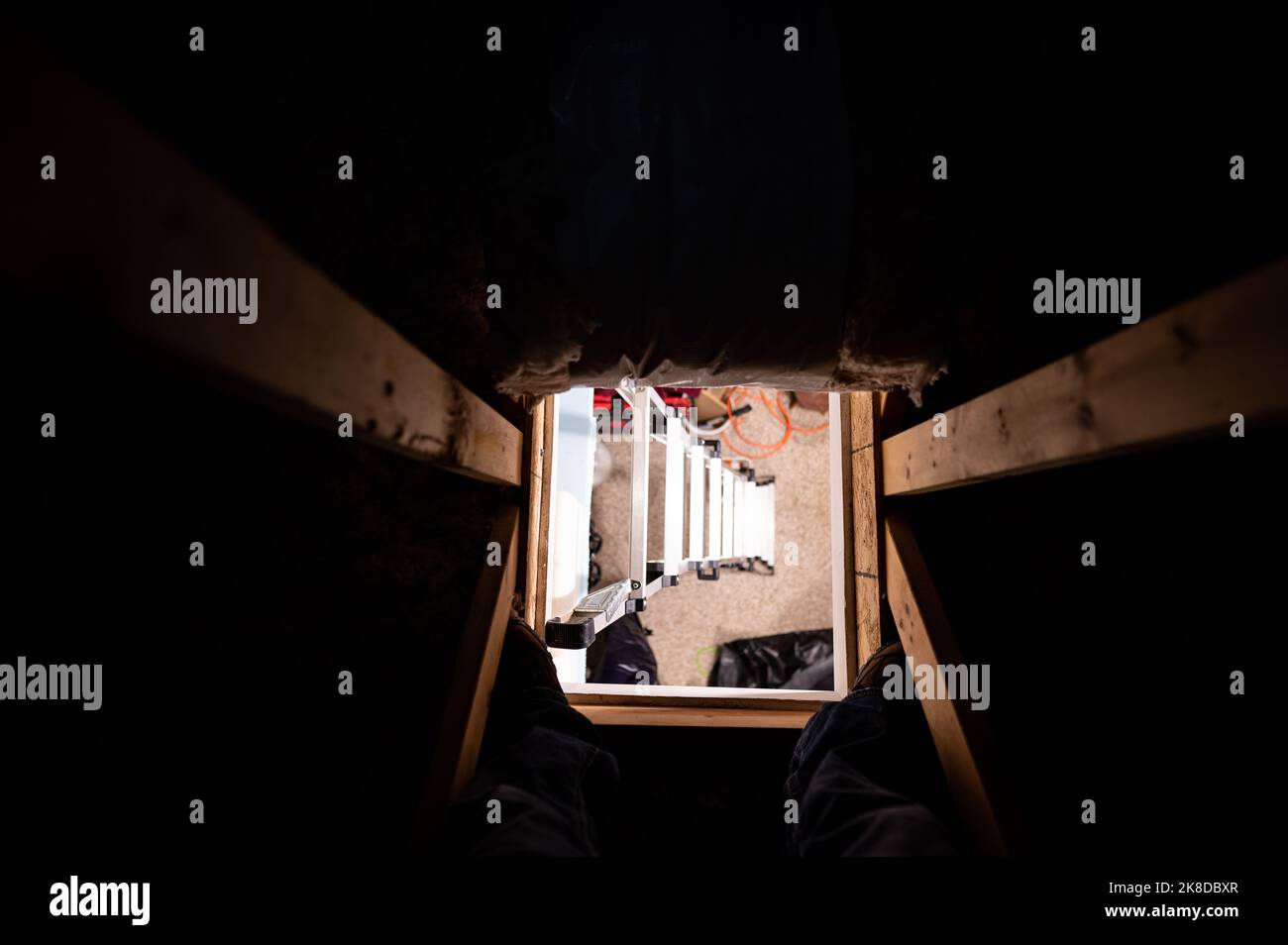 Looking down through the access opening to an attic with the ladder ...