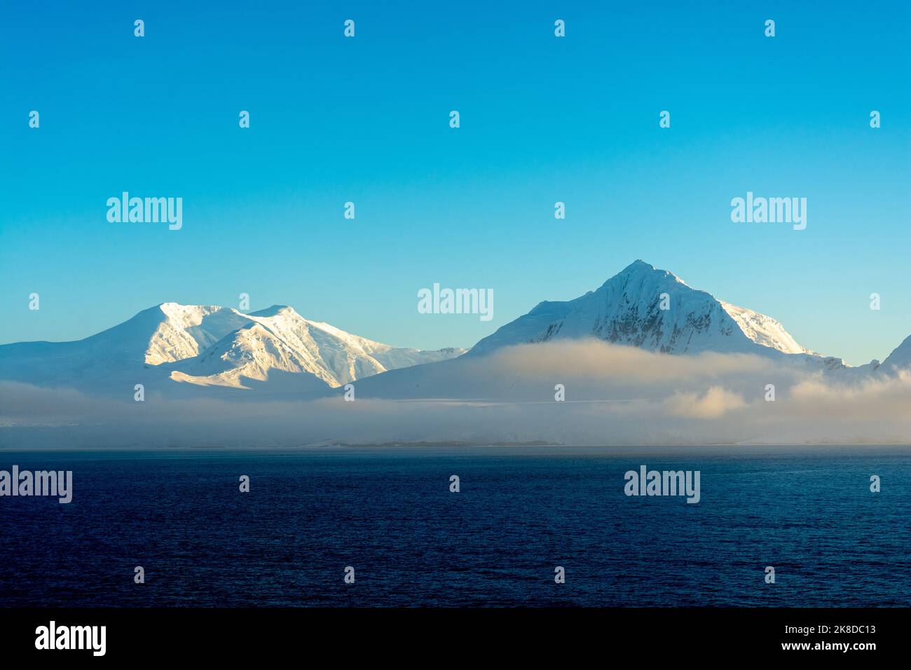 early morning sun on peaks of anvers island with mt. francais (l) and ...