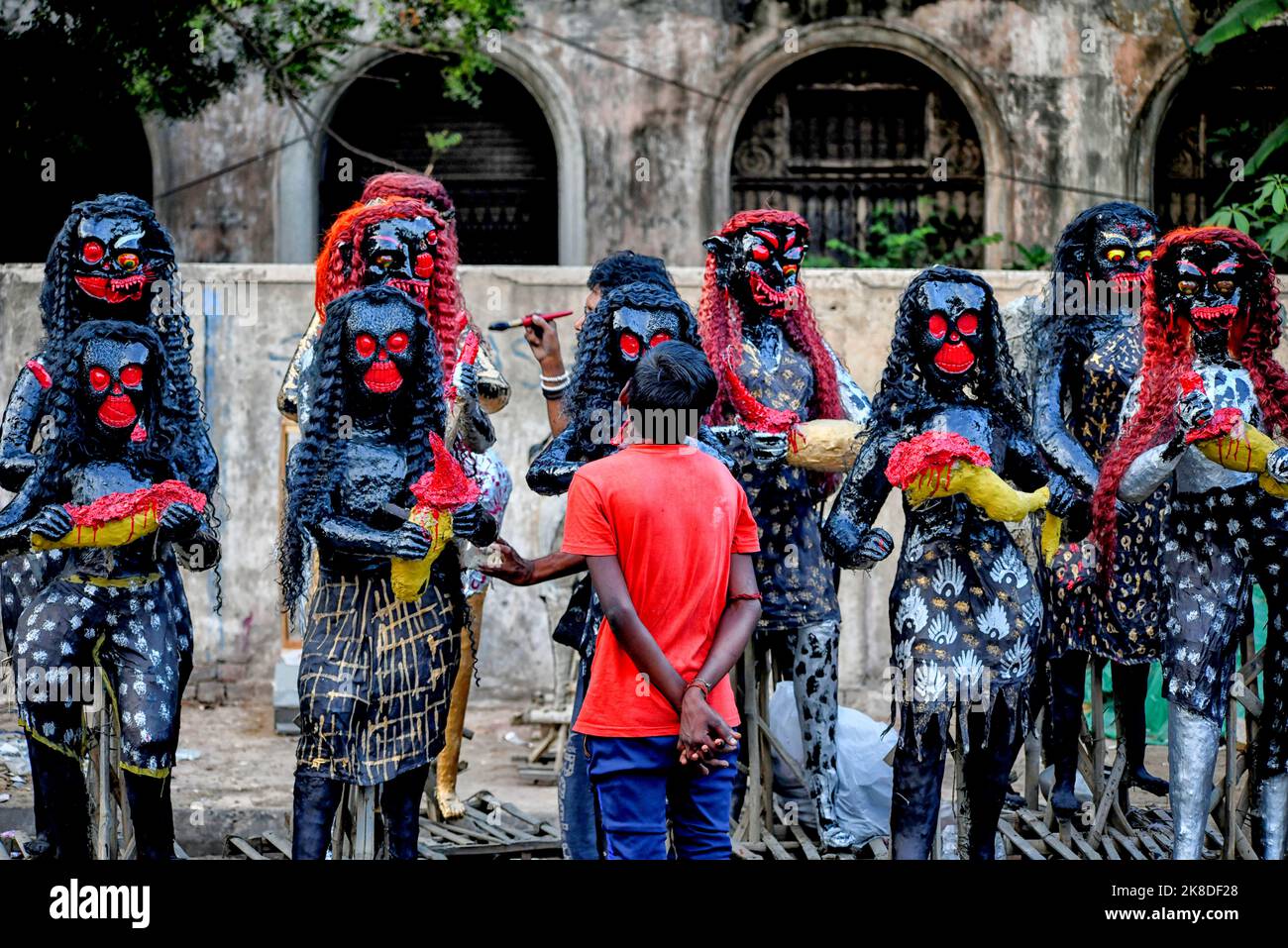 A child looks at the demon clay sculpture ahead of Kali puja festival ...
