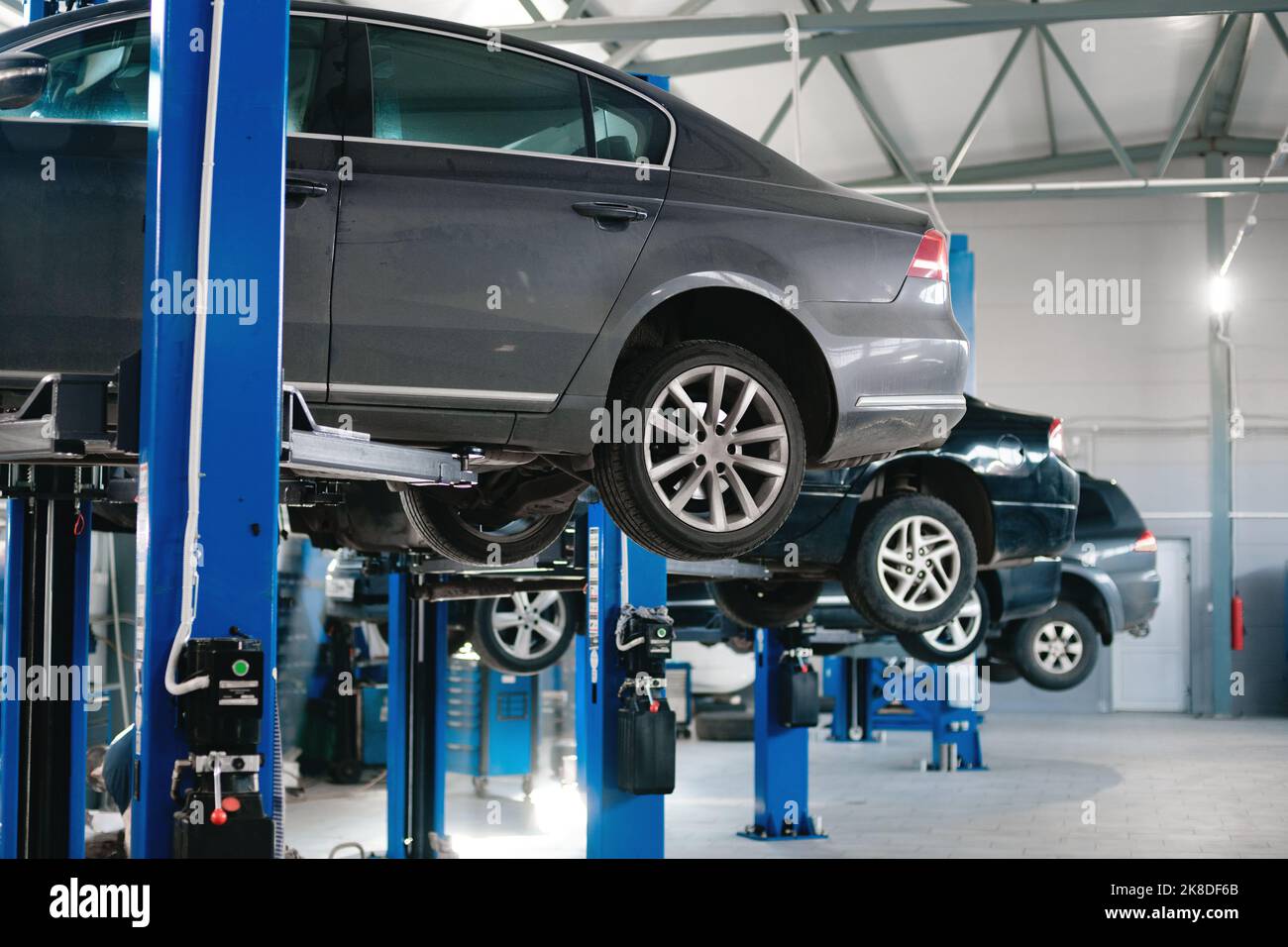 cars raised on car lifts located in a car service shop at a shallow ...