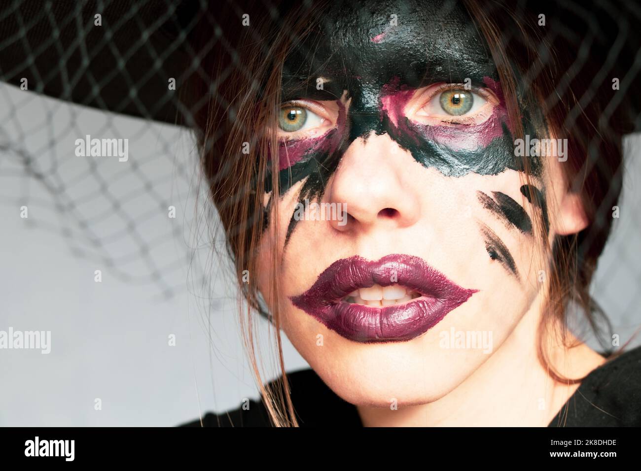 The image of a witch, witch makeup on the face of a girl and a hat of a ...