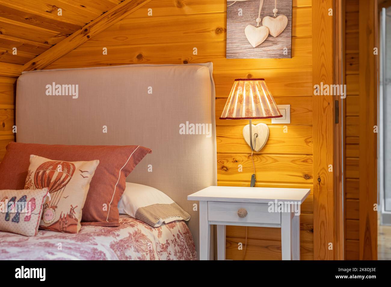 Cozy wooden bedroom interior with beautiful pillows on the bed and ...