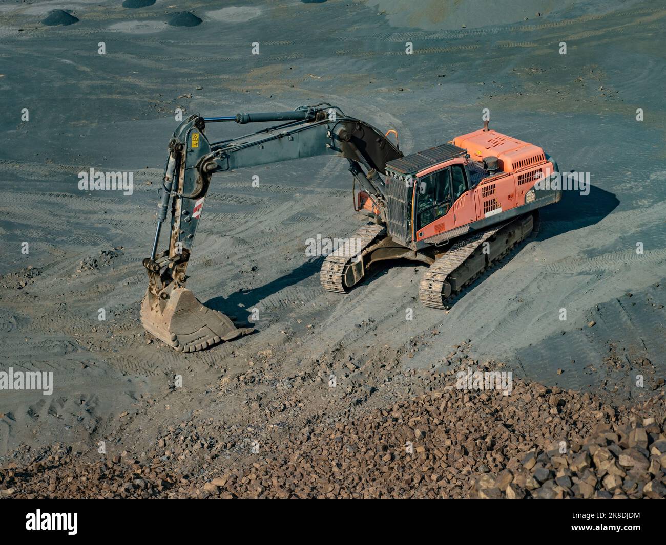 Industrial toothed digger bucket bite the ground in basalt mine. Loader ...