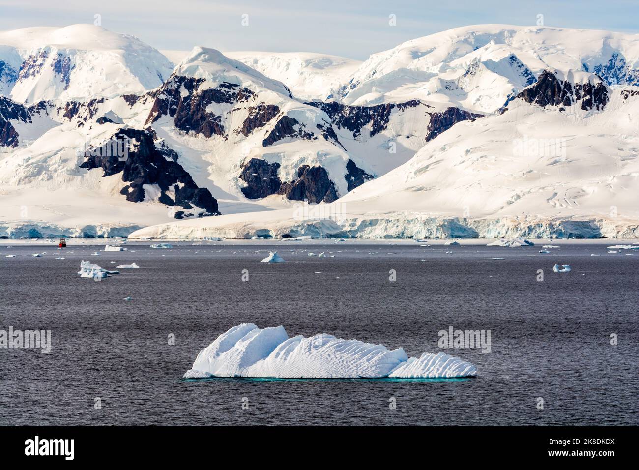 iceberg in gerlache strait with bryde island and antarctic peninsula in ...