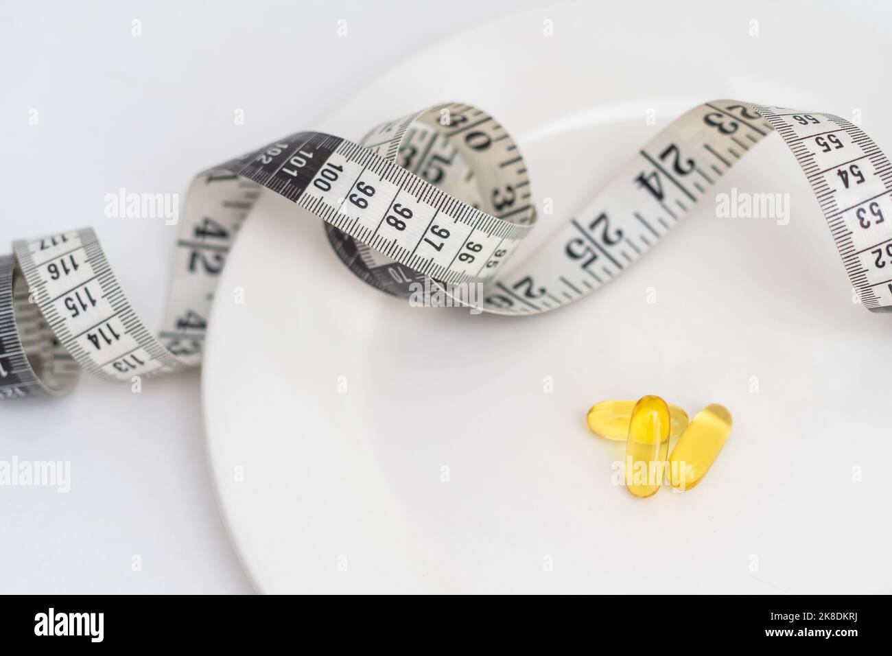 Flat lay composition with weight loss pills, plate and measuring tape ...