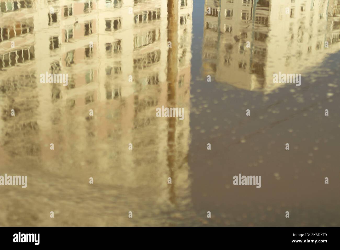 Building is reflected in puddle. Surface of water in city. Reflection ...