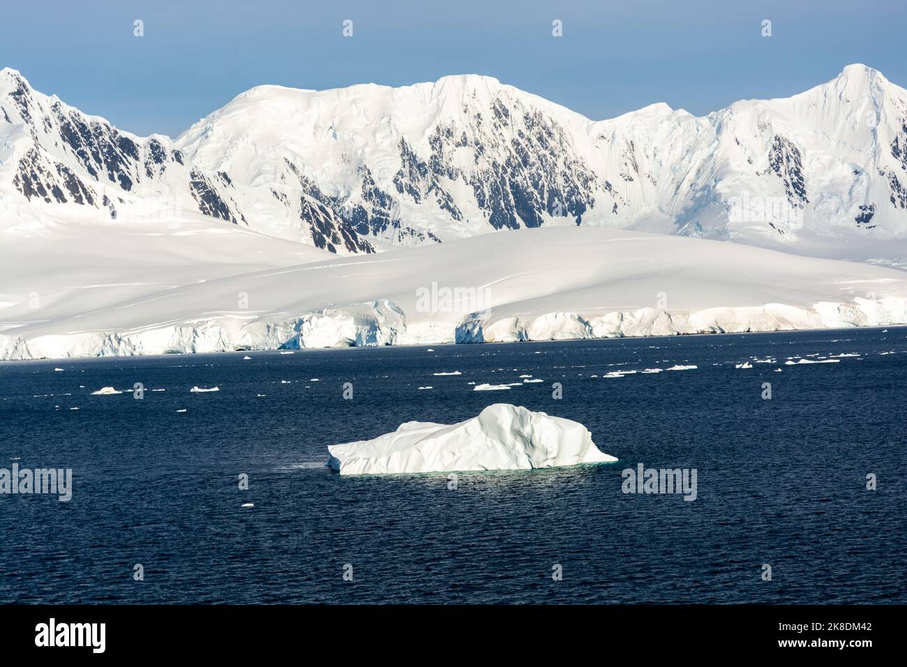small iceberg in waters of neumayer channel. with snow and ice covered ...