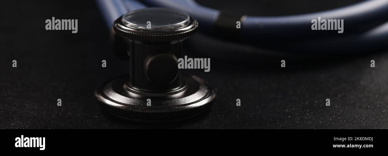 Medical stethoscope instrument on black surface, tool for patient ...