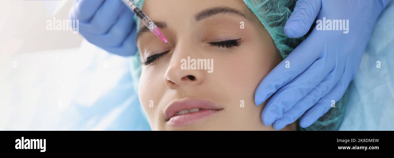 Young lady gets injection of botox in her nose, cosmetologist using ...
