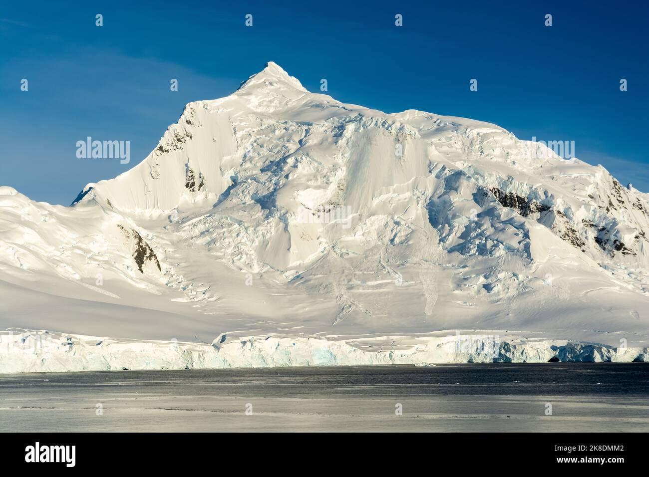 early morning sun lights up snow covered mt. william on anvers island ...