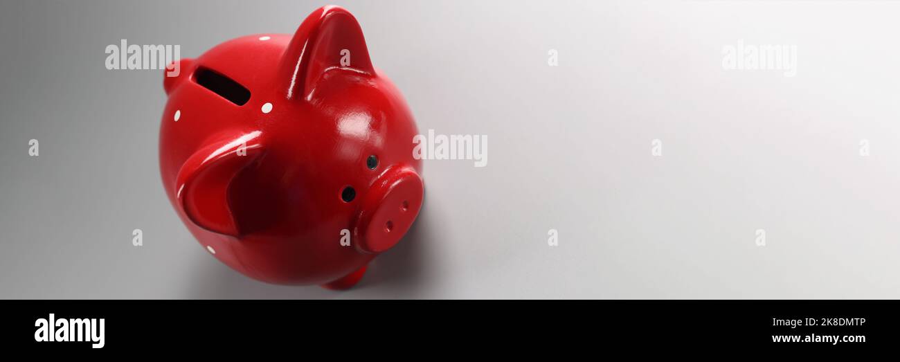 Red piggybank container on grey surface with hole for coins, empty ...