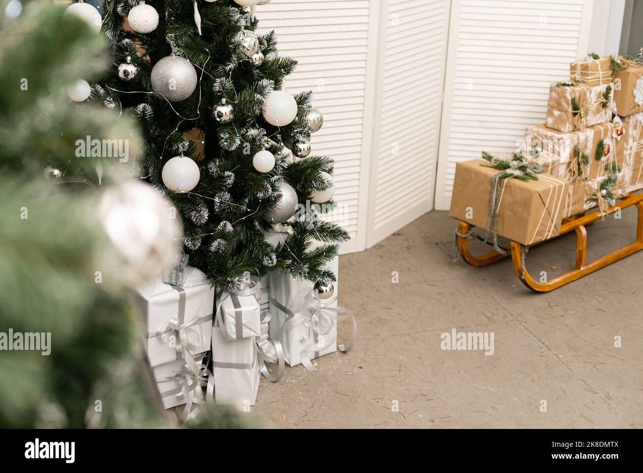 Christmas tree with wooden rustic decorations and presents under it in ...