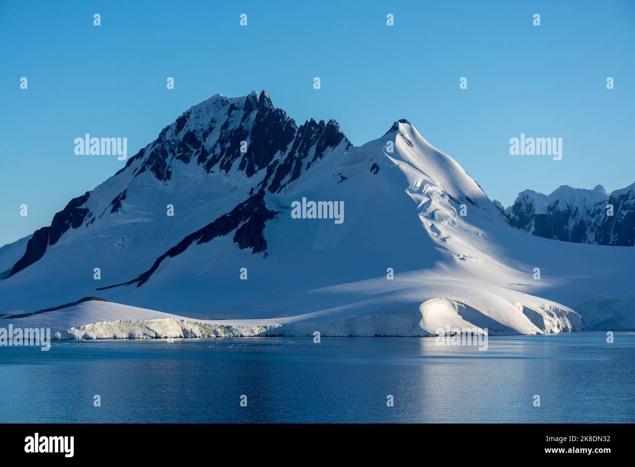 early morning sun on jabet peak (r) and noble peak (l) on wiencke ...