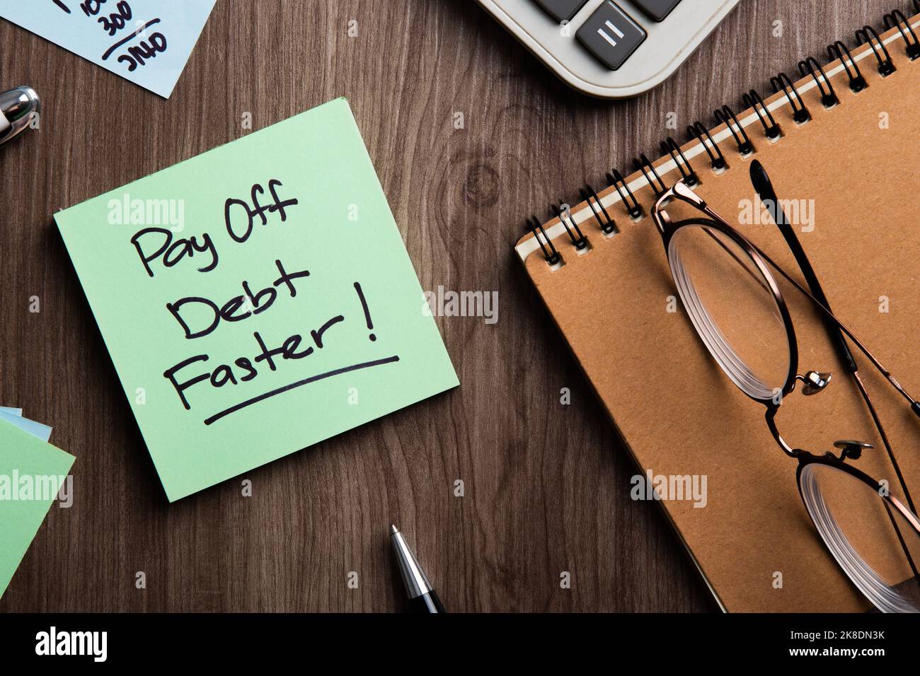 Pay off debt faster handwritten on memo Stock Photo - Alamy