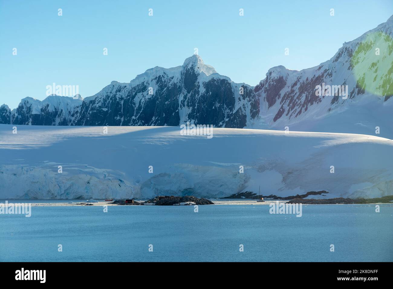 port lockroy station on goudier island with snow covered shore and wall ...