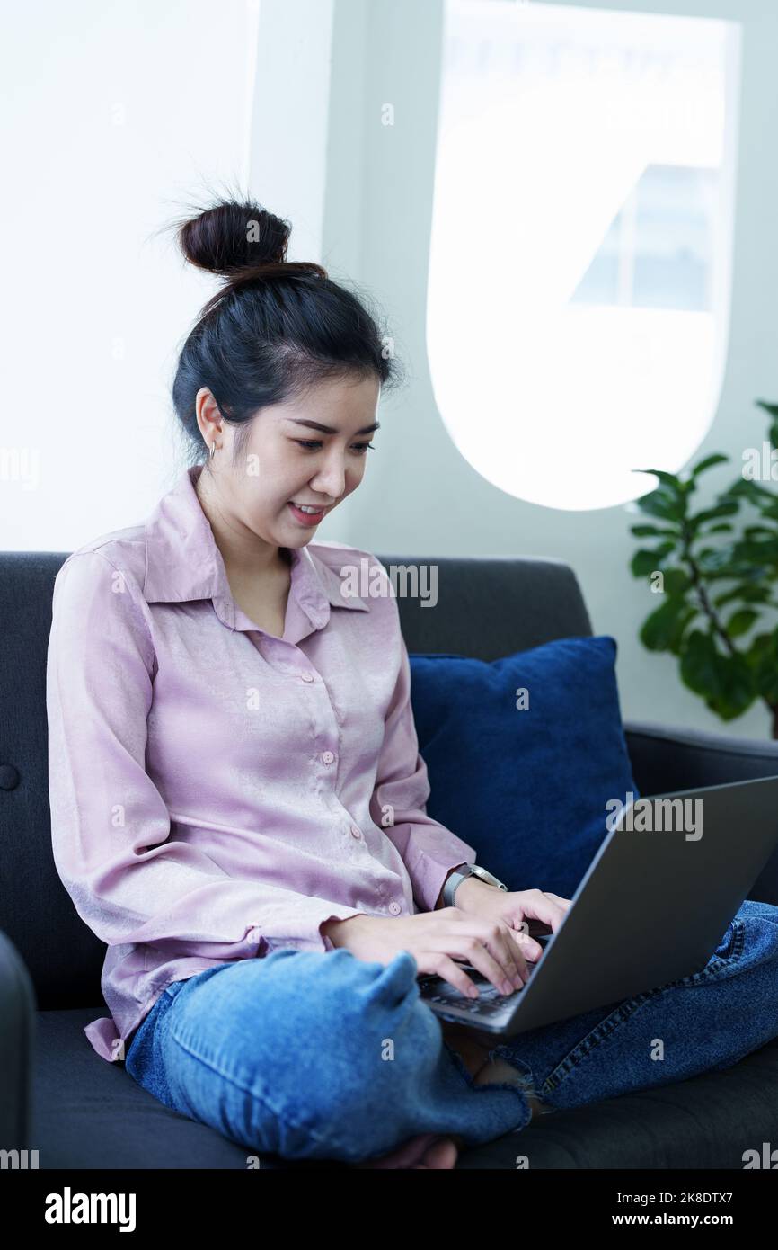 Portrait of a self-employed Asian woman using a computer at home Stock ...