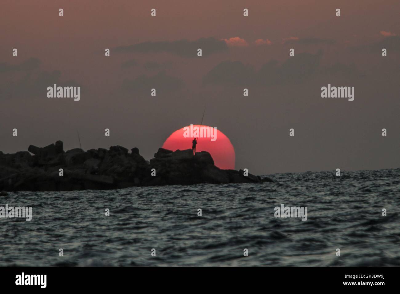 Silhouetted Palestinian man seen fishing using a fishing rod during the ...