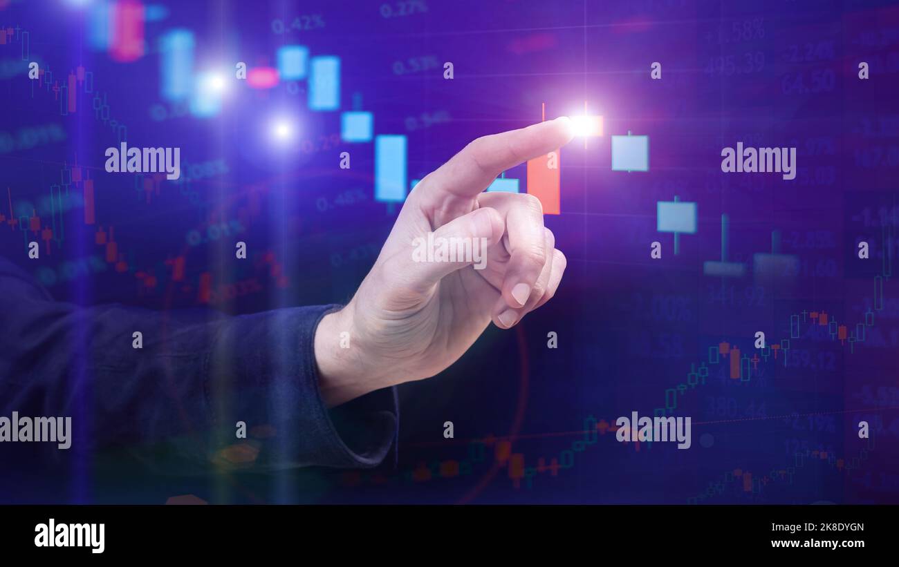 The trader points his finger at the stock chart on the monitor Stock ...