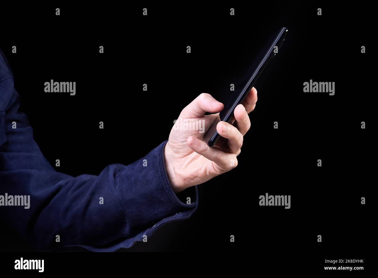 Man presses his finger on the screen of a smartphone on a dark ...