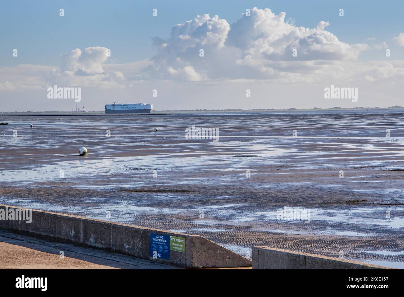 Wadden Sea on the beach promenade with car transport ship in the Weser ...