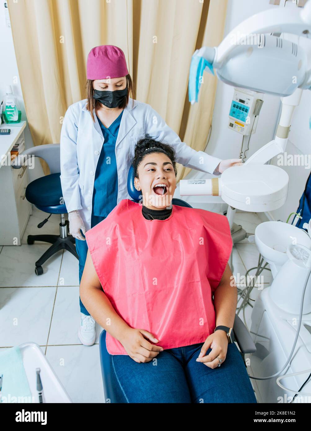 Dentist performing intraoral radiography assessment on a patient, a ...