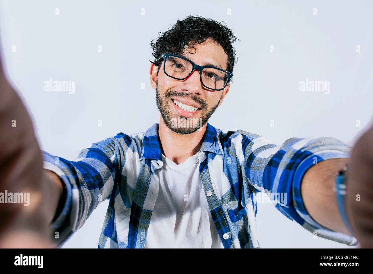 Handsome man taking a selfie looking at the camera on isolated background. Teenage guy taking a ...