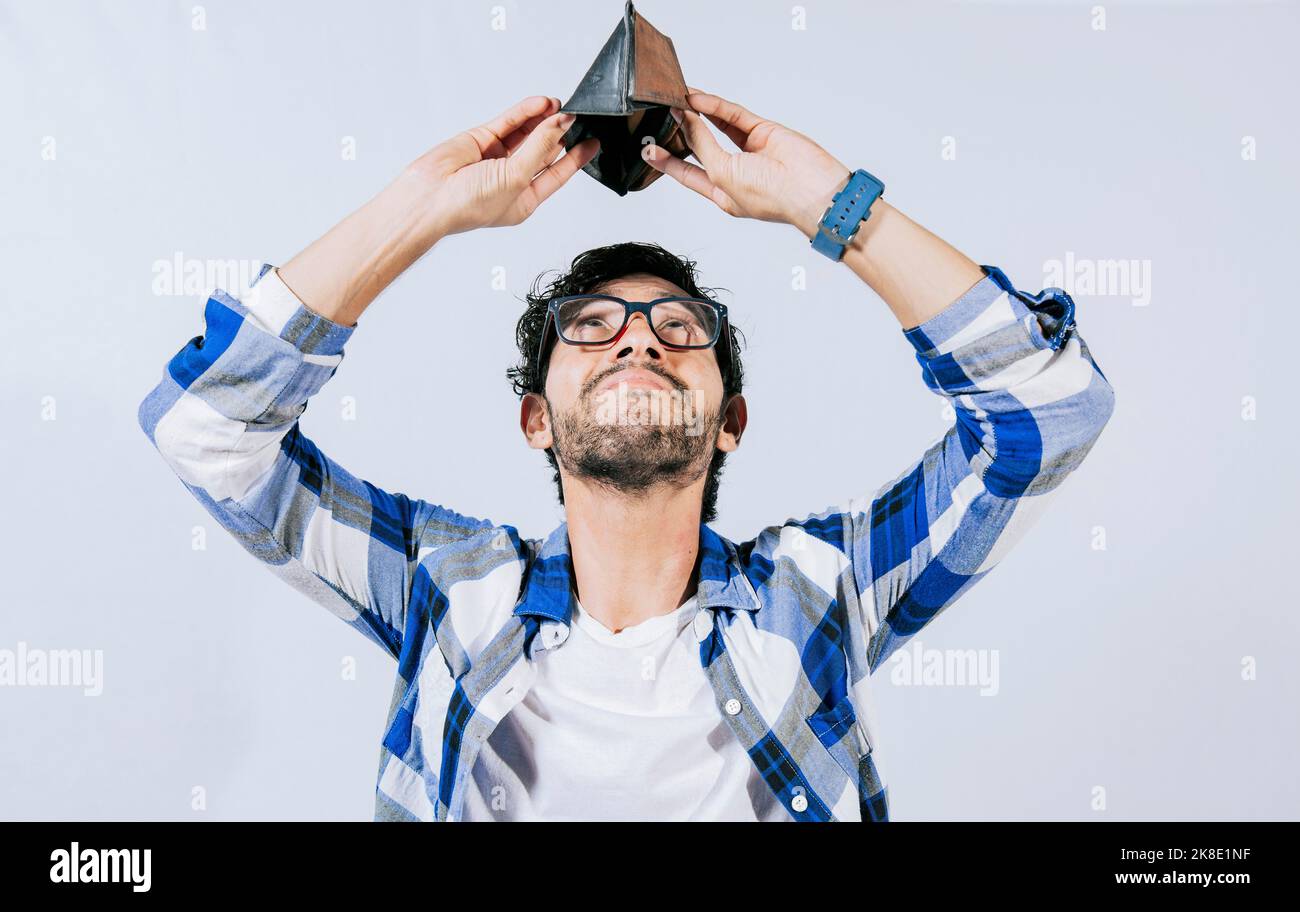 Sad man shaking an empty wallet. Sad person shaking an empty wallet ...