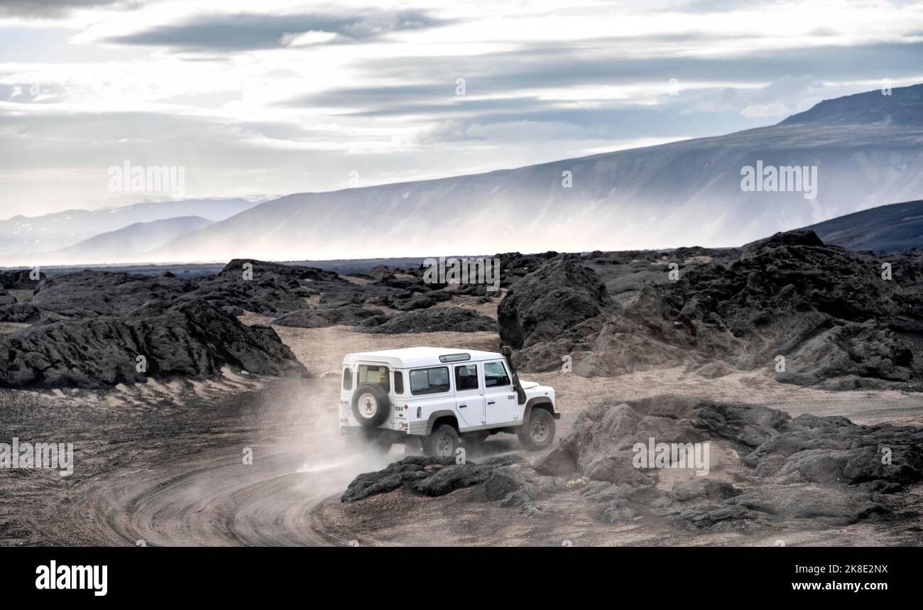White Land Rover on a dirt road, volcanic landscape, barren landscape ...