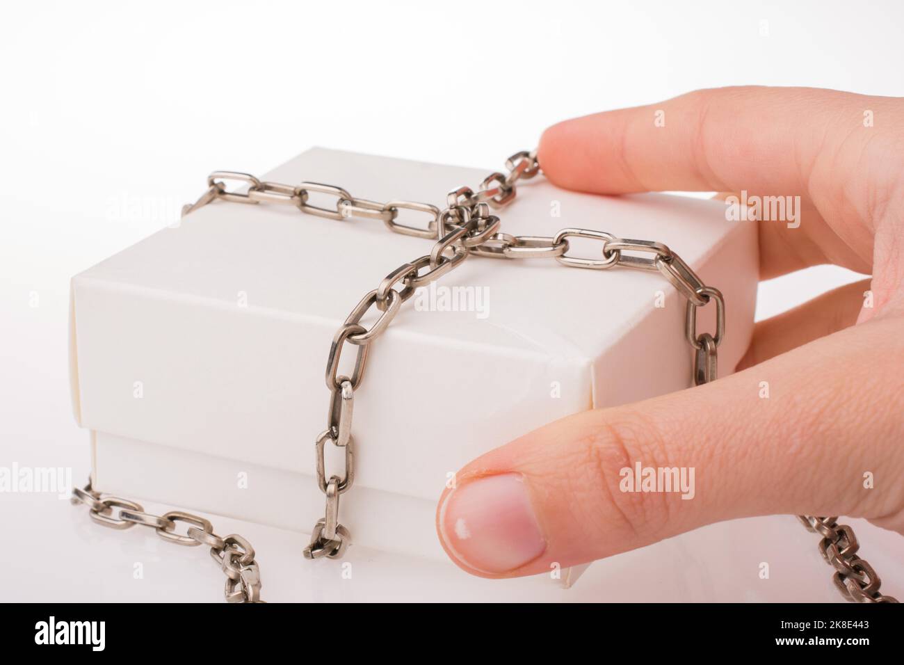 Hand holding a gift box with a chain around Stock Photo - Alamy