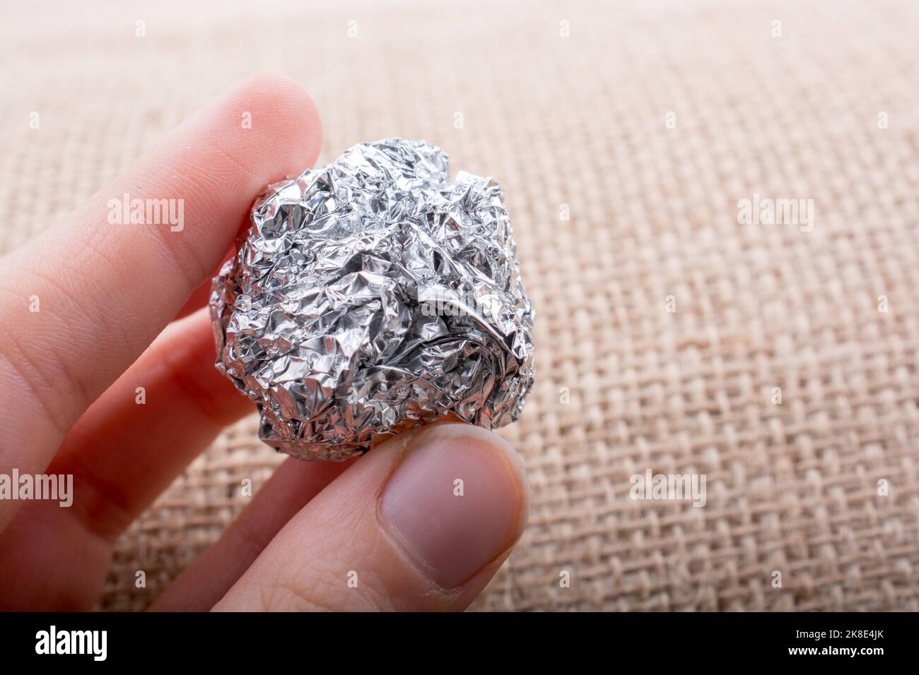 Aluminium foil in the shape of a sphere on a textured background Stock ...