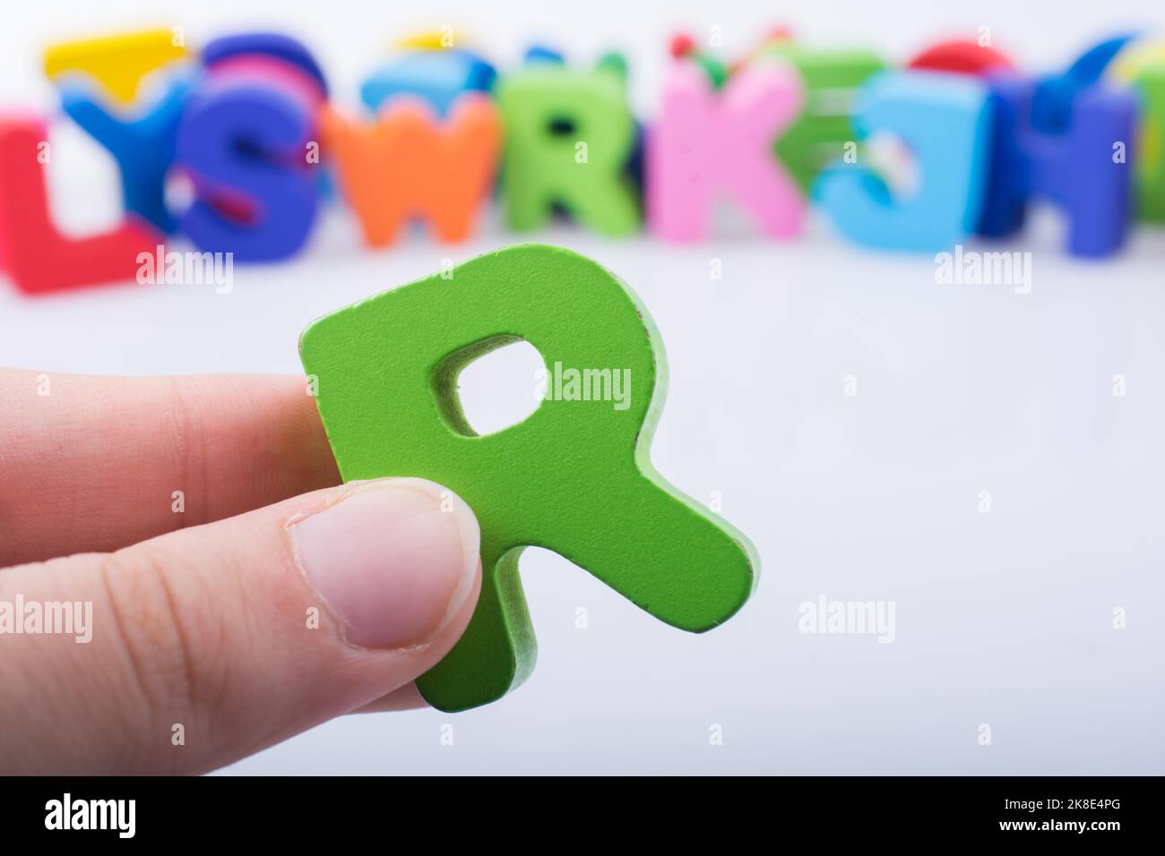 Hand holding letter cube R of made of wood Stock Photo - Alamy