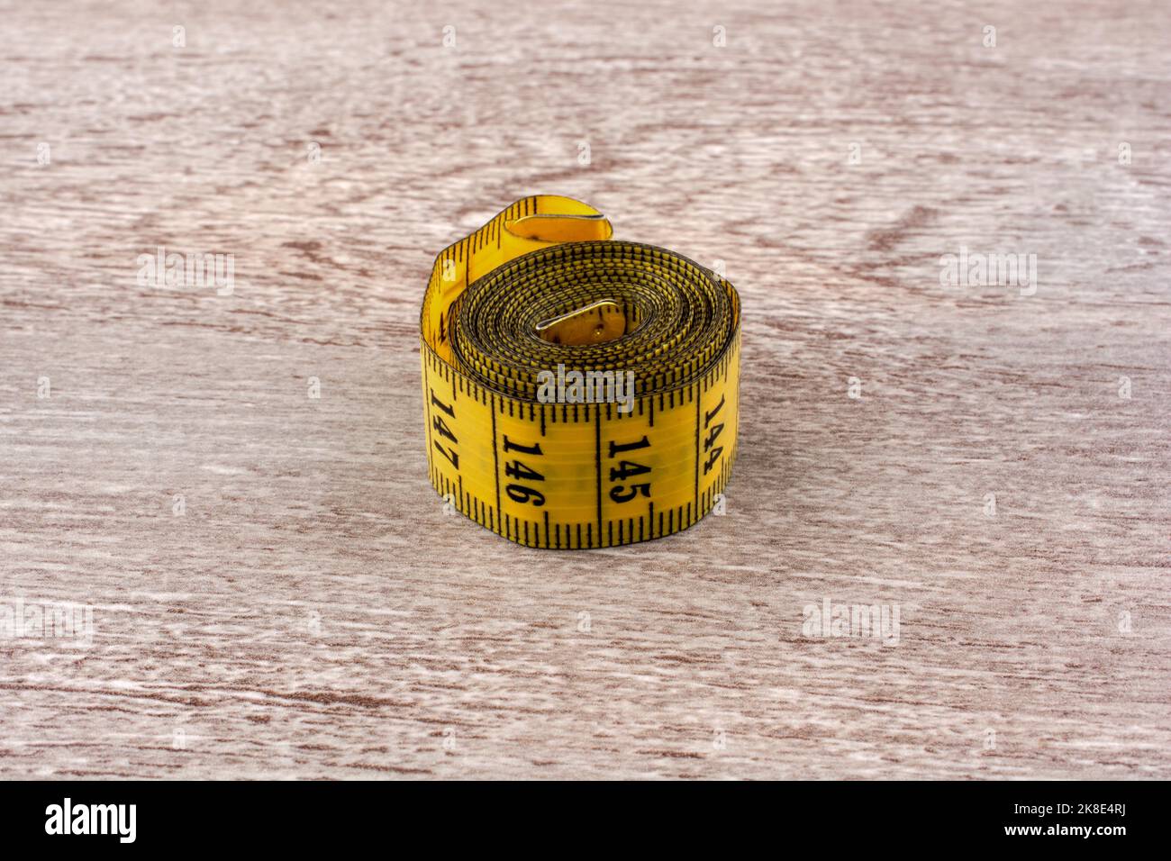Yellow color Tape measure roll on a grey background Stock Photo - Alamy