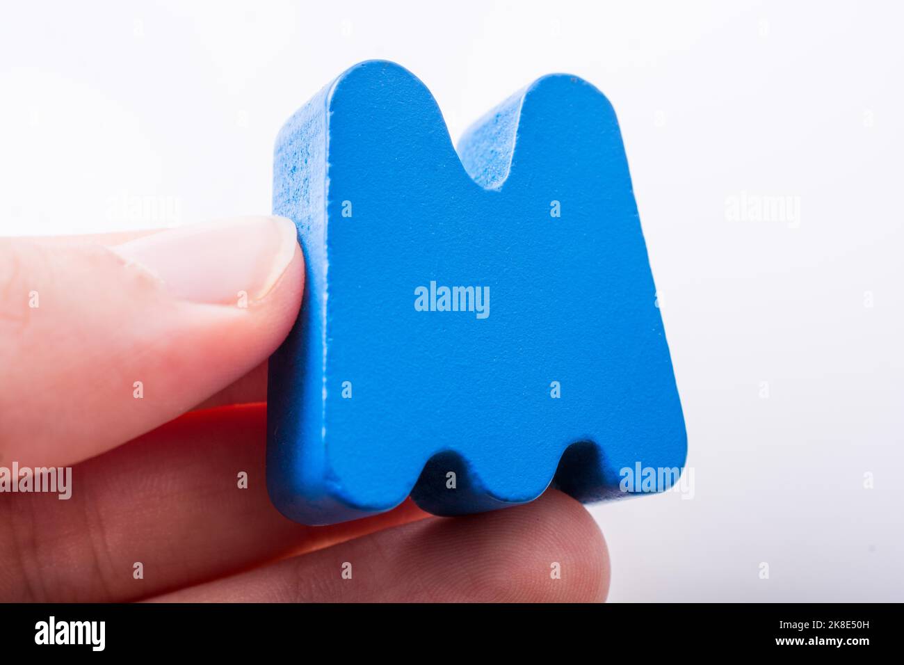 Hand holding letter cube M of made of wood Stock Photo - Alamy