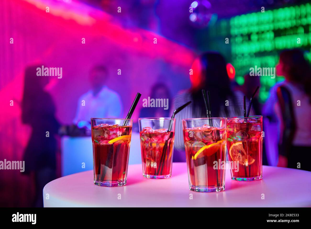 Alcoholic cocktails in a nightclub against the backdrop of dancing ...