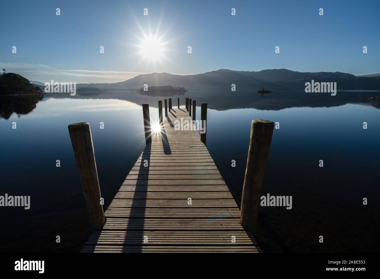 Sun star reflected in Derwentwater oa beautiful calm morning sunrise at ...
